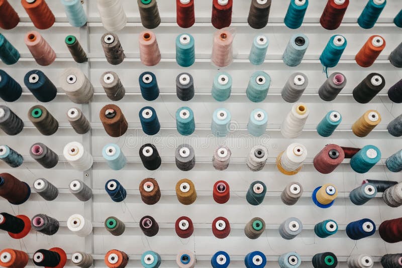 Front View of Colorful Thread Spools on a White Wall Display Stock ...