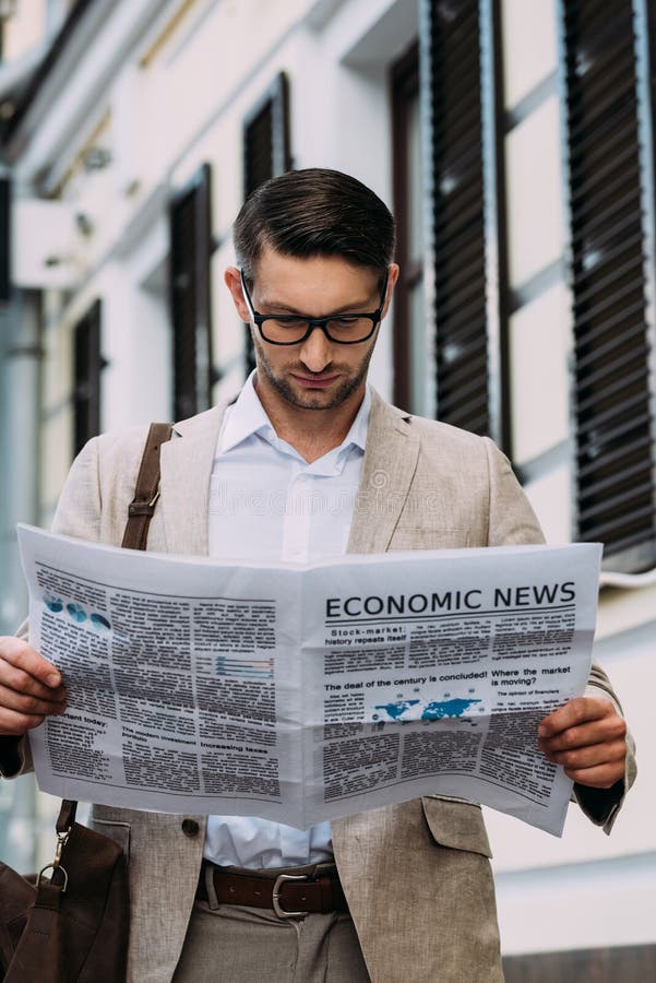 View of Concentrated Man in Glasses Reading Newspaper on Street Stock ...
