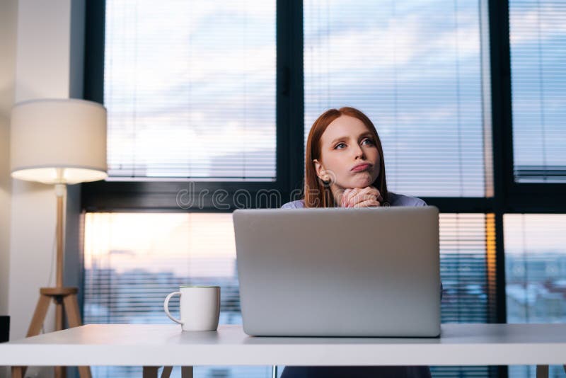 Front View of Concerned Redhead Woman Working on Laptop Computer ...