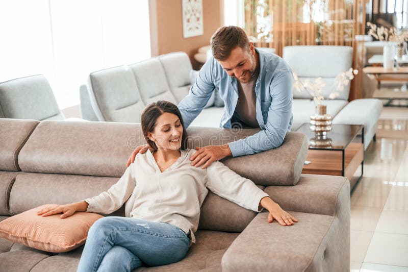 Front View. Couple Choosing the Sofa and Bed in the Store Stock Photo ...