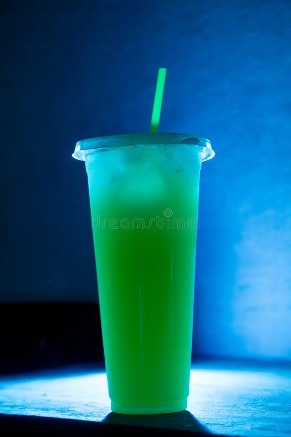 Front View, a Cup of Green Liquid with a Straw Inside Lies on a Wooden ...