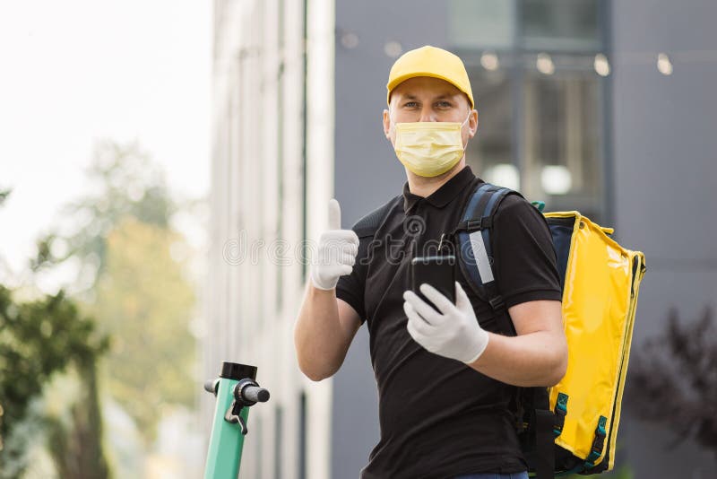 Front View of Delivery Man in Face Mask Using Smartphone and Riding ...