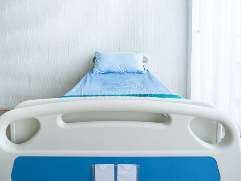Front View of an Empty Hospital Bed Featuring Blue Bedding and a Pillow ...