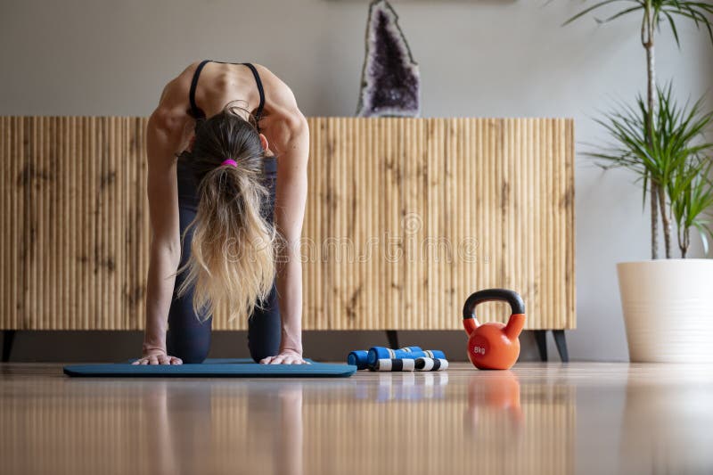 Front View of a Fit Young Woman Exercising at Home on a Mat Practicing ...