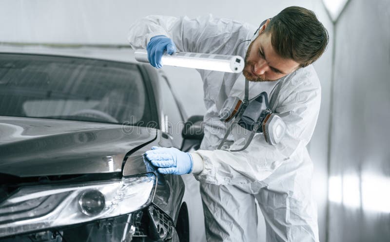 Front View. Garage Worker is Holding Lighting and Checking Surface of ...