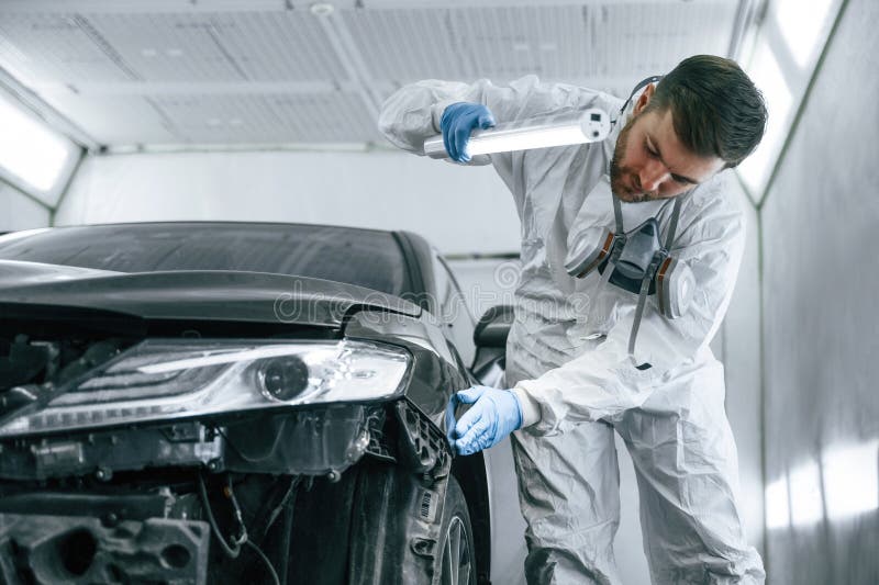 Front View. Garage Worker is Holding Lighting and Checking Surface of ...