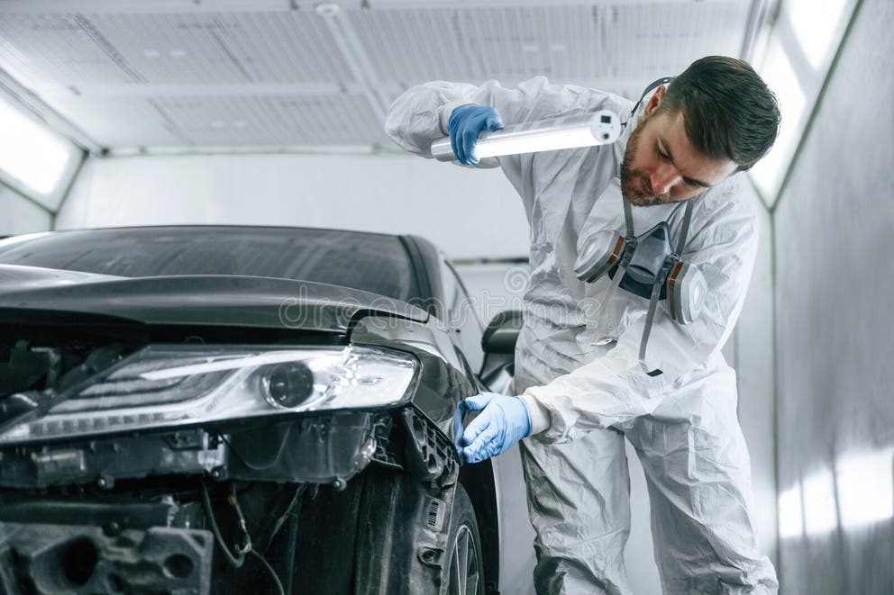 Front View. Garage Worker is Holding Lighting and Checking Surface of ...