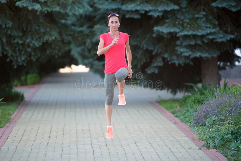 Front View of a Girl Doing Exercise Outdoor in a Park, Jogging Stock ...