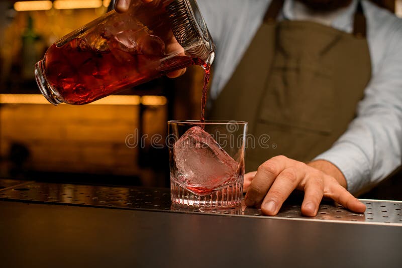 Front View of Glass with Ice Cube in Which Pours Cocktail from Mixing ...