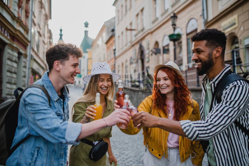 Front View of Group of Happy Young People with Drinks Outdoors on ...