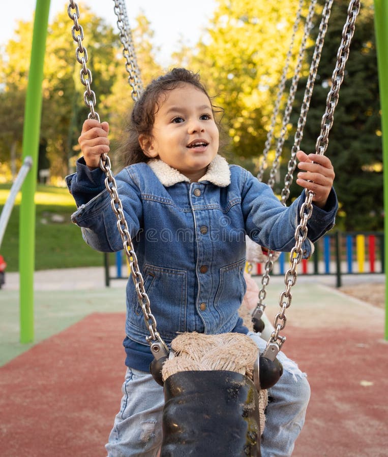 Front View of a Happy Dominican Kid Boy Having Fun in a Swing Outdoors ...