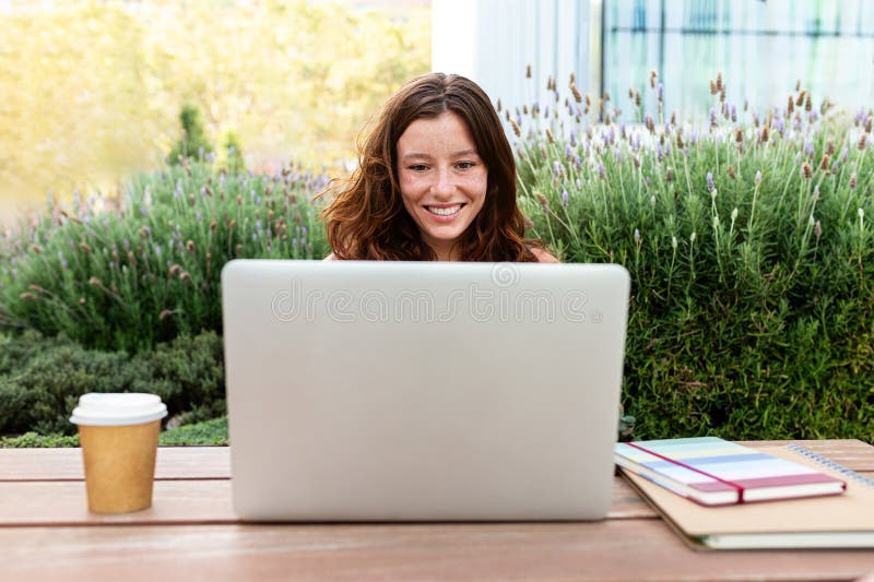 Front View of Happy Redhead Female College Student Using Laptop ...