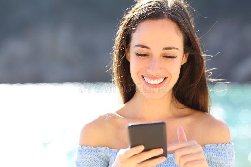 Front View of a Happy Woman Using Smart Phone on the Beach Stock Image ...