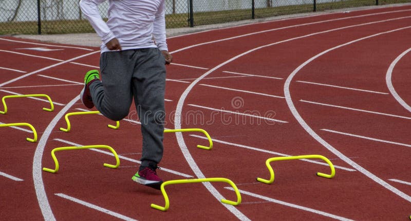 High School Boy Running Over Yellow Mini Hurdles Stock Photo - Image of ...