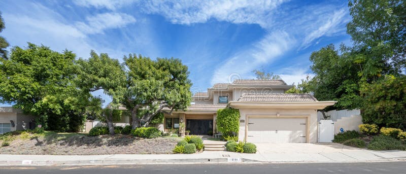 The Front View of a Home Surrounded by Trees and Bushes Stock ...