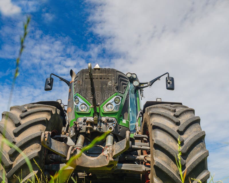 Front View of Large Tractor on a Summer Field. Cloudy Sky in the ...