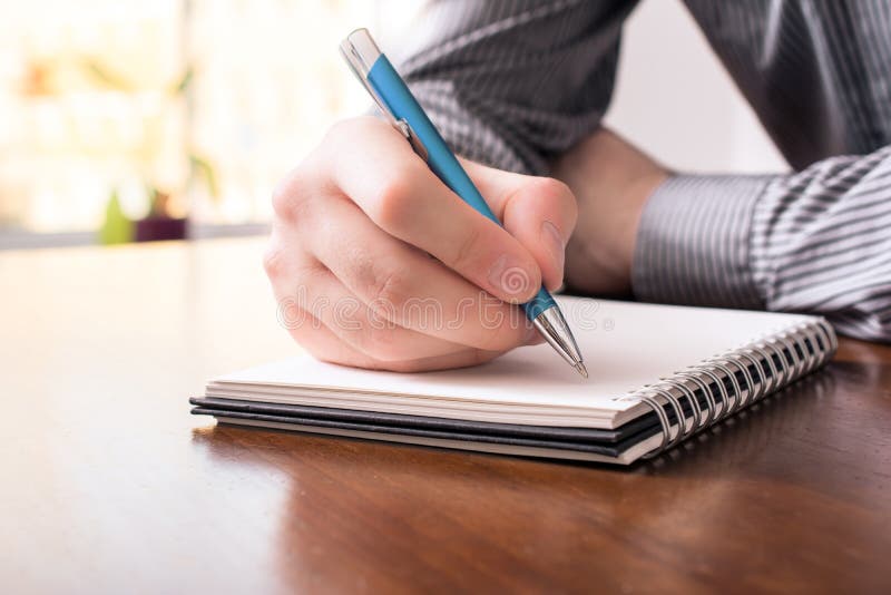 Front View of a Man in Business Shirt Writing in a Blank Notepad with a ...