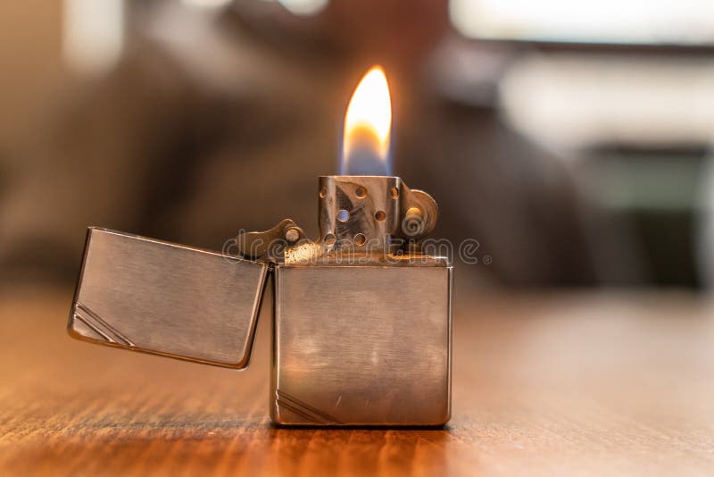 Front View on Metal Lighter on the Table Lighting Fire in Day Stock ...