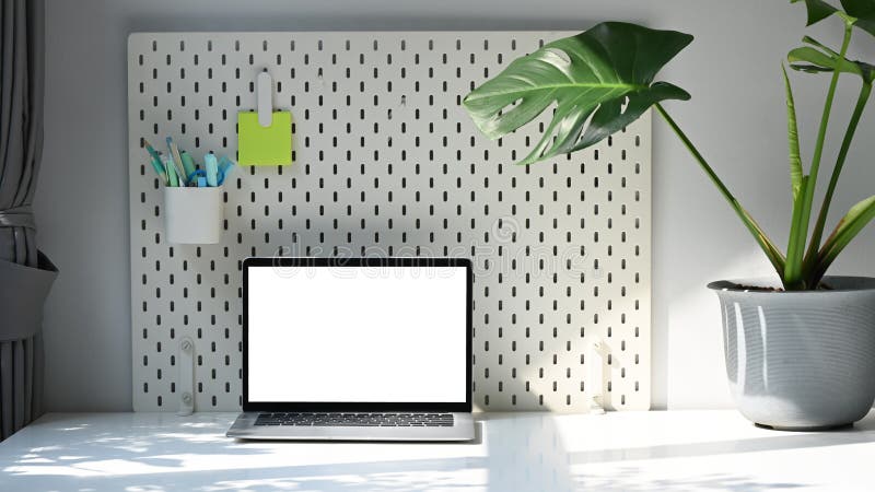 Front View Laptop Computer, Potted Plant and Pegboard on White Table ...