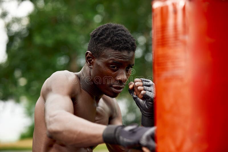 Front View of Muscular Black Boxer Punching Towards Camera with a Deep ...