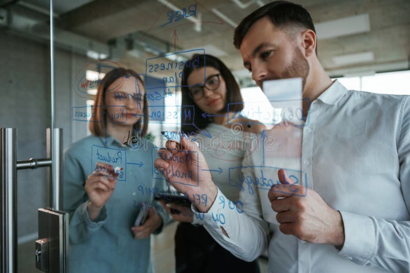 Front View. Office Workers are Creating Plan, Standing by Glass and ...
