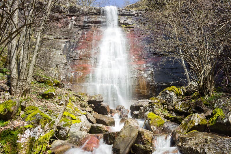 Powerful, Sunlit Waterfall Streaming Down the Red Cliff Stock Image ...