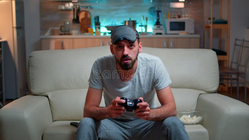 Front View of Pro Gamer Sitting on Sofa in Front of Television while ...