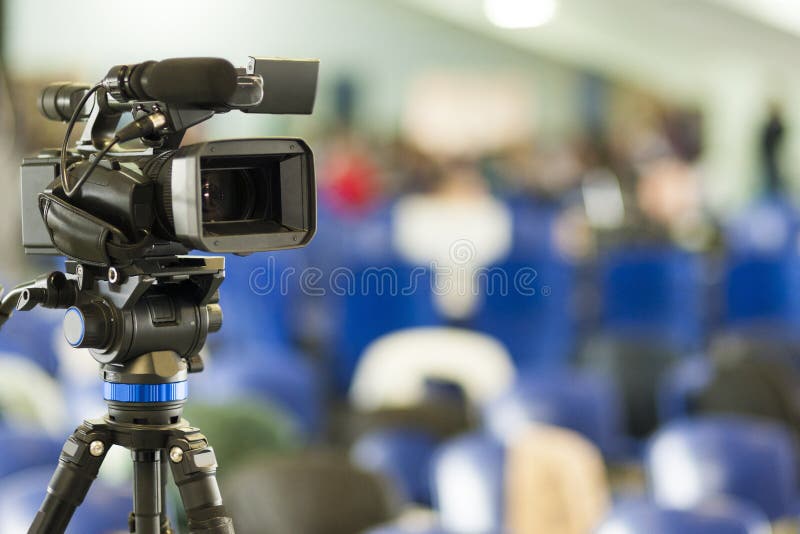 Front View of Professional Videocamera. Positioned Against Blurred ...