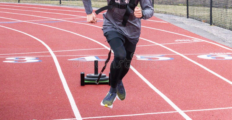Front View of a Runner Pulling a Sled with Weights on a Track Stock ...