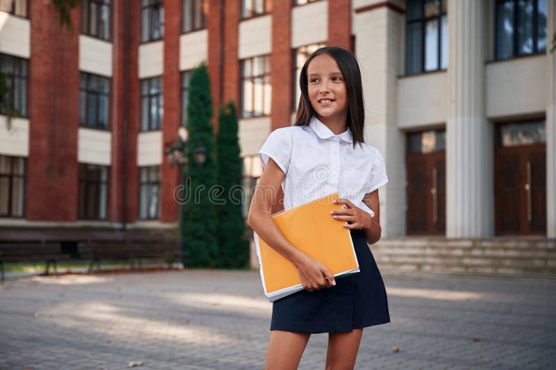 Front View. School Girl in Uniform is Outdoors Near the Building Stock ...
