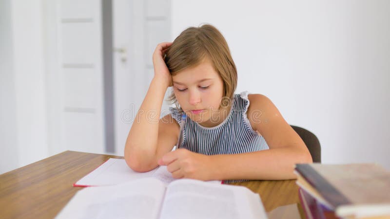Front View Schoolkid Sits at Desk, Does Homework with Left Hand Looking ...