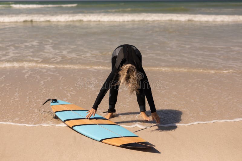Front View of Senior Female Surfer with Surfboard Exercising on the ...