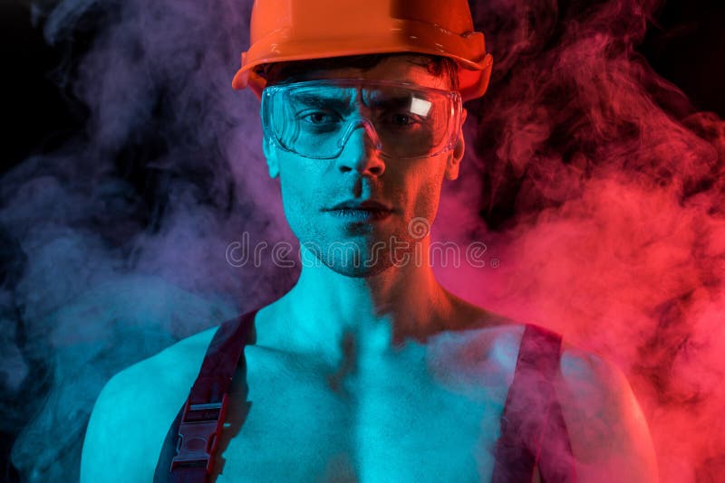Fireman in Hardhat and Protective Goggles Holding Fire Hose in Smoke on ...