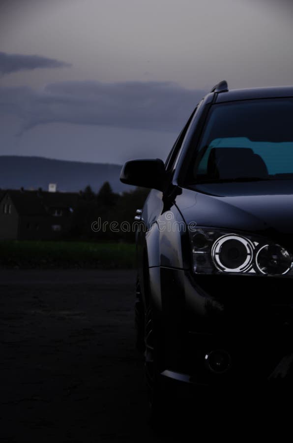 Front View Shot of a Shiny Luxury Car Outdoors Under Dark Sunset Sky ...