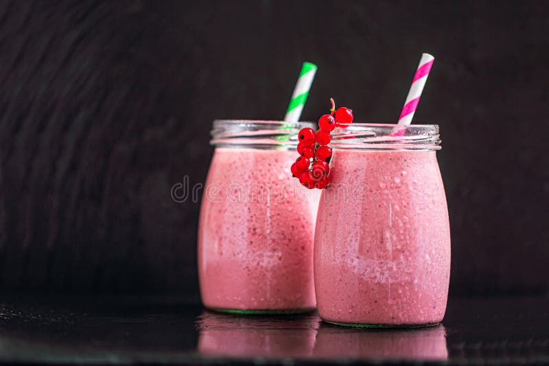Front View of Two Berries Milkshakes in Glass Jars with Currant on ...