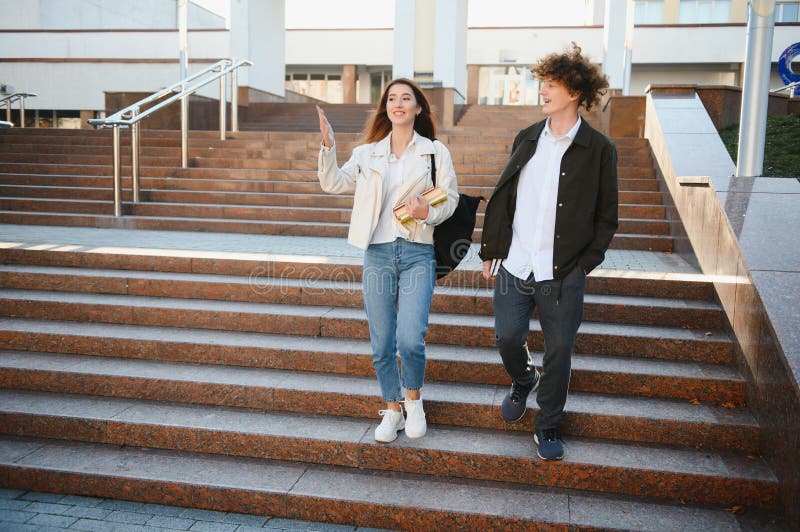 Front View of Two Students Walking and Talking in an University Campus ...