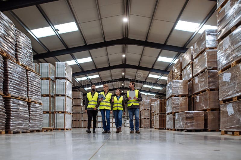 Front View of Warehouse Workers Walking in Warehouse. Team of Warehouse ...