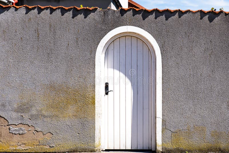 Front View of White Arched Closed Door on Worn Grey Wall Conveys End of ...