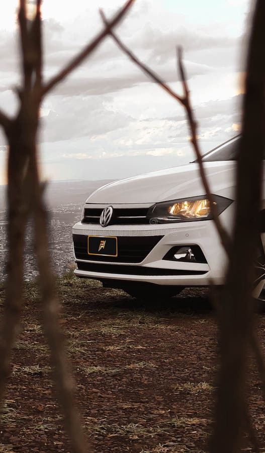 Front View of a White Volkswagen Polo through Dead Tree and Cloudy Sky ...