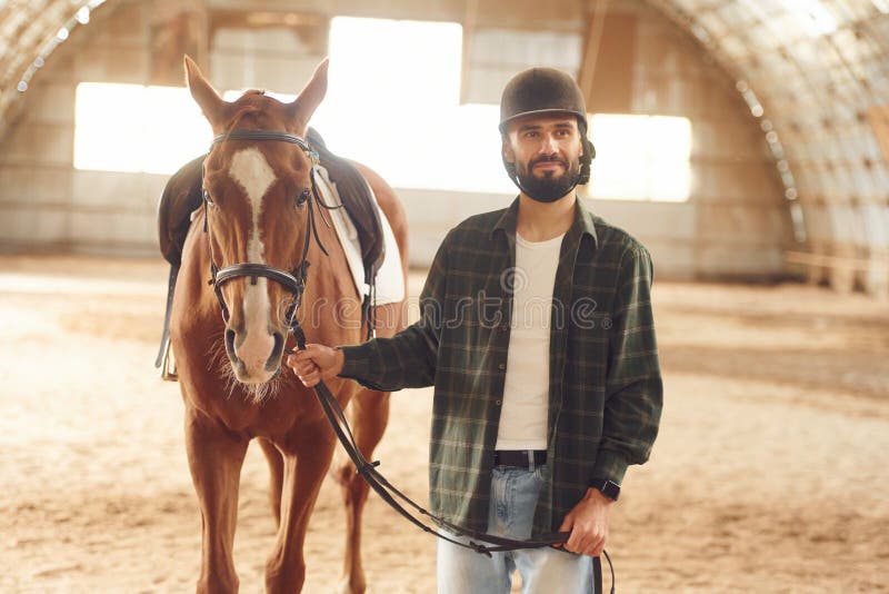 Front View. Young Man with a Horse is in the Hangar Stock Photo - Image ...