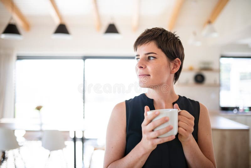 Front View of Young Woman with Coffee Standing Indoors at Home. Stock ...