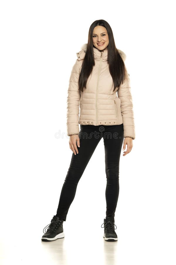 Front View of a Young Woman in Winter Jacket, and Black Jeans Posing on ...