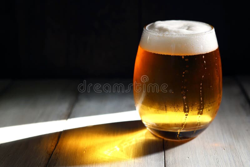 A Frothy Beer Poured into a Short, Rounded Glass Stock Photo - Image of ...