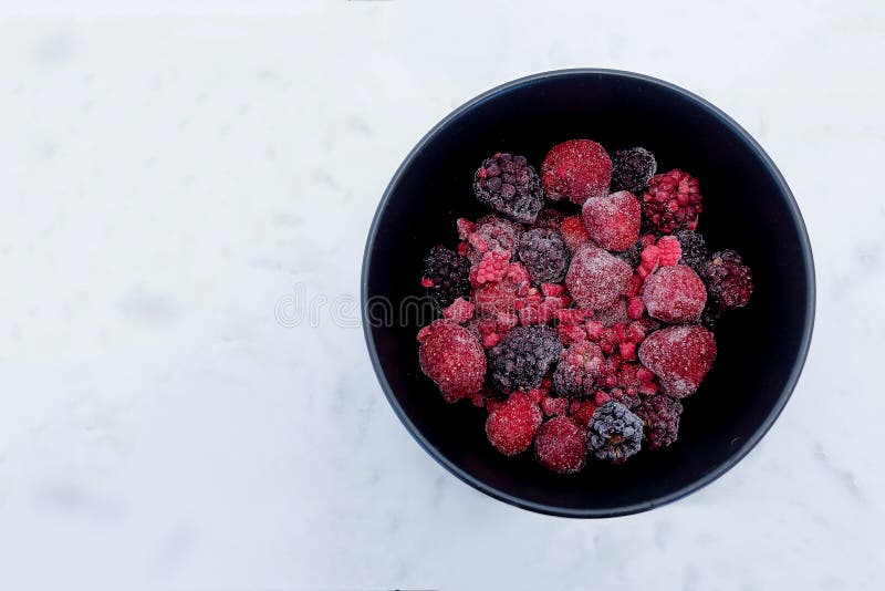 Frozen Berries in Black Bowl on White Marble Surface Stock Image ...