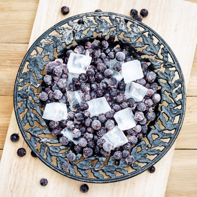 Frozen Black Currant with Pieces of Ice on a Vintage Plate Stock Photo ...