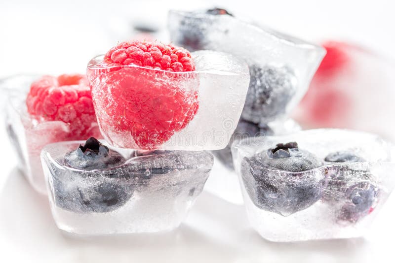 Frozen Blueberry and Raspberry in Ice Cubes on White Background Stock ...