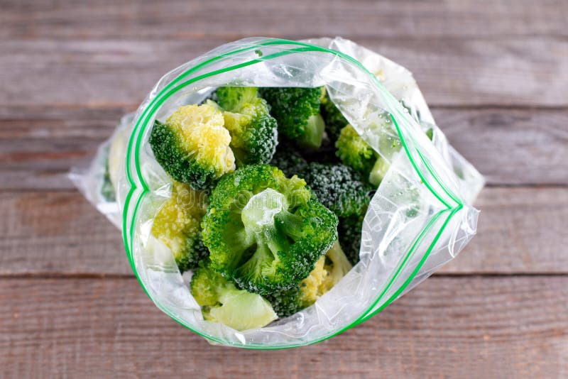 Frozen Broccoli in a Plastic Bag on Wooden Table. Selective Focus Stock ...