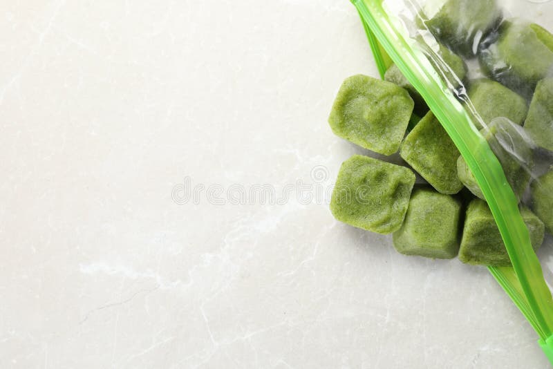 Frozen Broccoli Puree Cubes in Plastic Bag on White Marble Table, Top ...