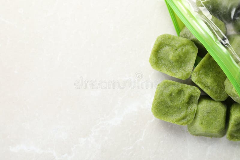 Frozen Broccoli Puree Cubes in Plastic Bag on White Marble Table, Top ...