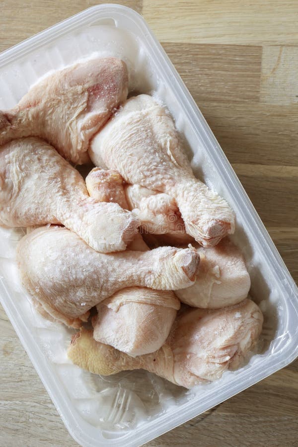 Frozen Chicken Drumsticks in a Plastic Container Defrosting. Stock ...